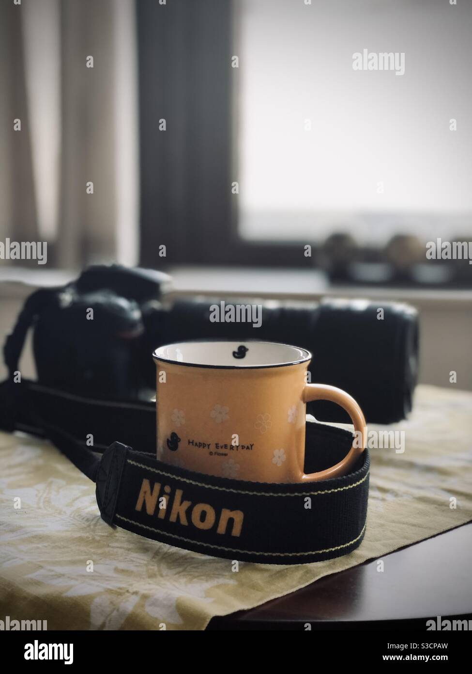 Camera Nikon and yellow coffee cup Stock Photo - Alamy
