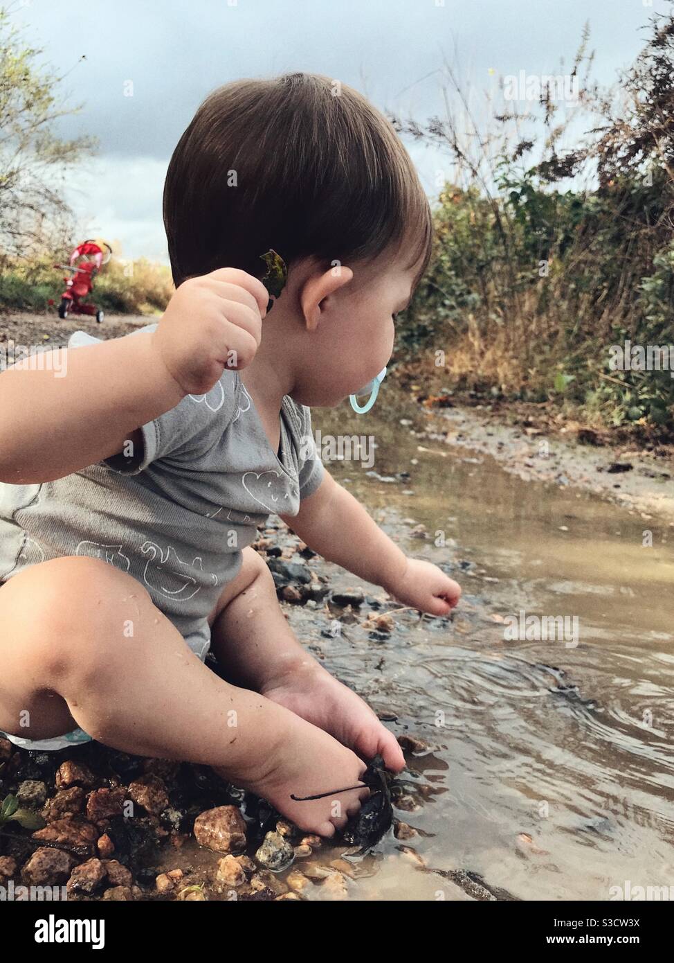 Baby plays in puddle Stock Photo - Alamy