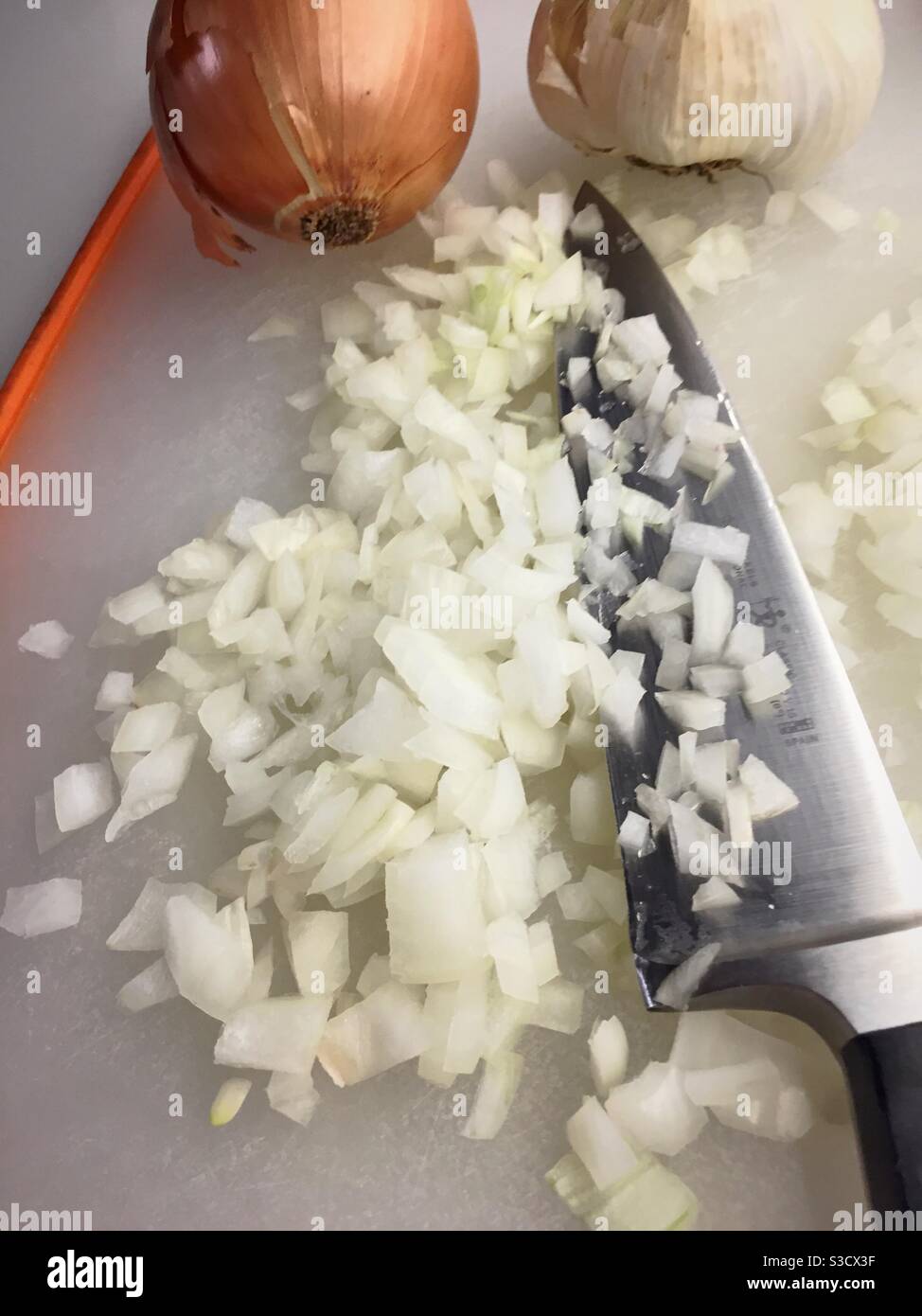 Freshly chopped onion and a large prep knife on a residential kitchen ...
