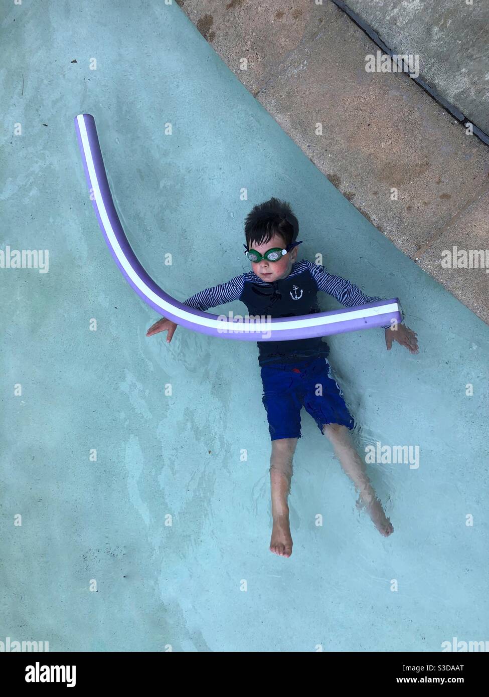 Boy floating in swimming pool Stock Photo - Alamy