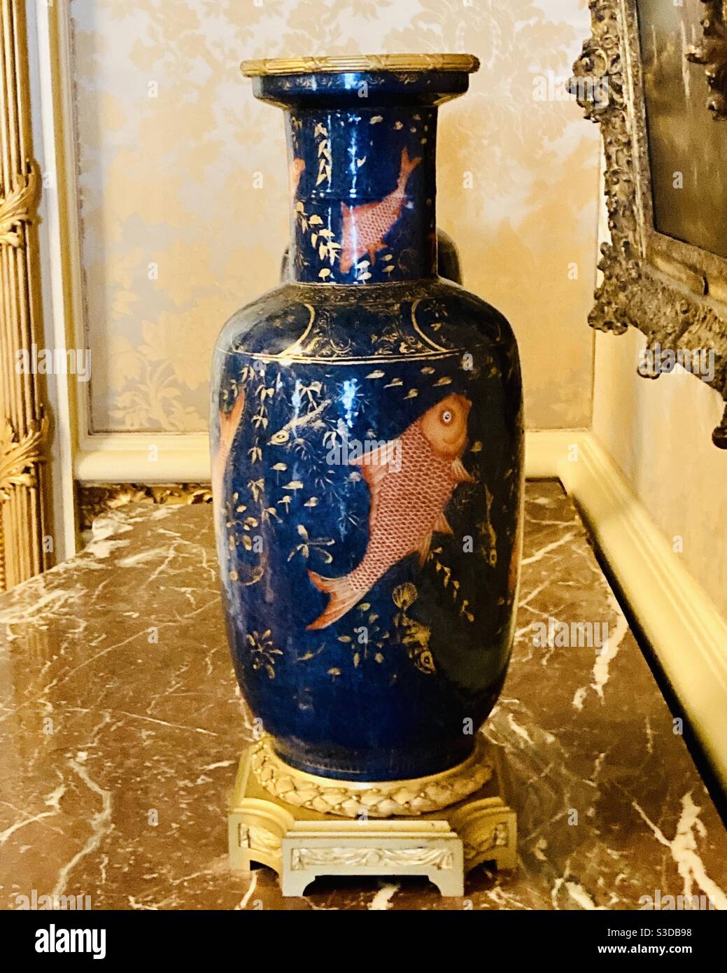 Oriental vase sitting at a table vase has fish drawing Stock Photo - Alamy