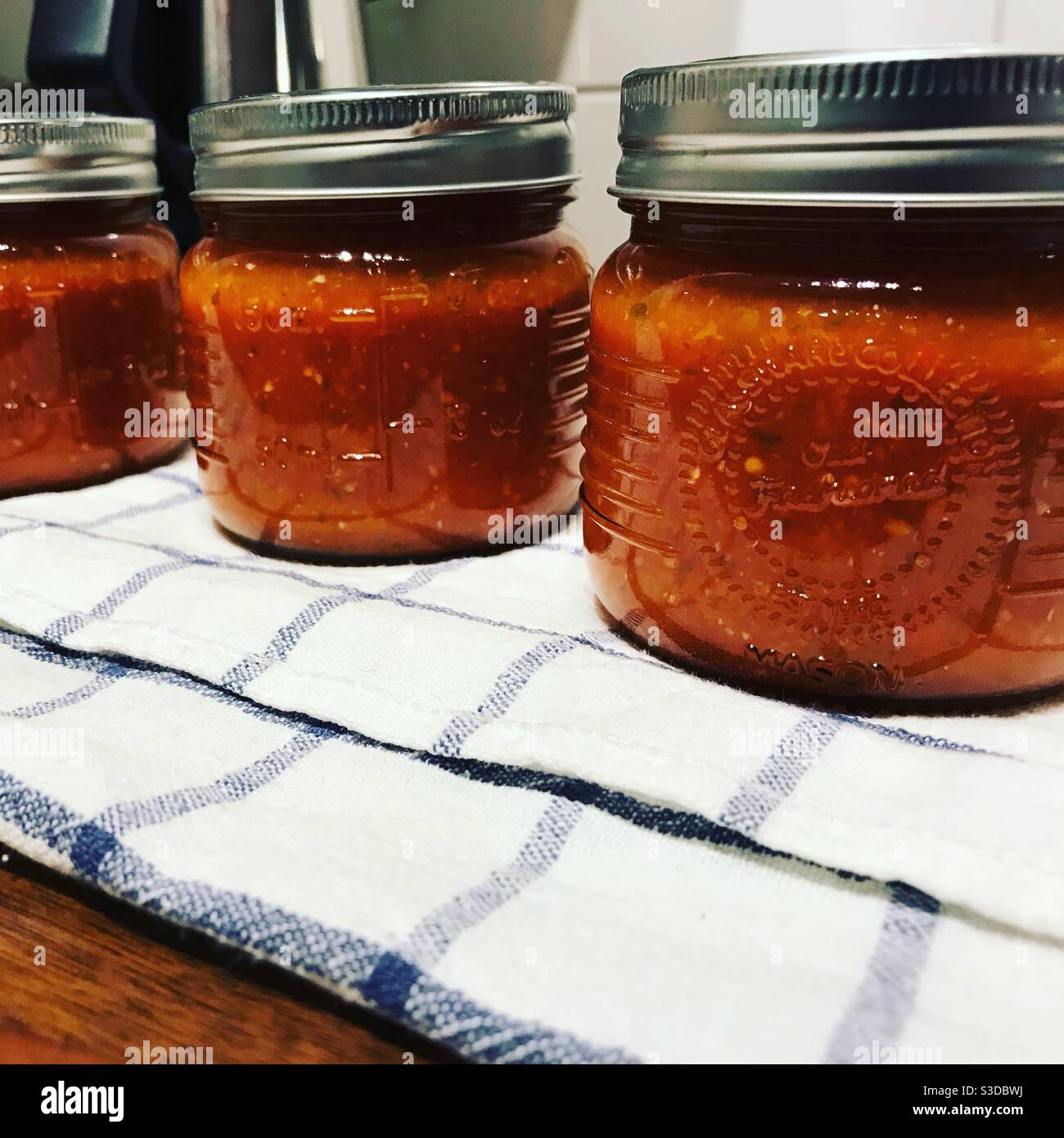 Jars of red salsa on a kitchen towel Stock Photo - Alamy