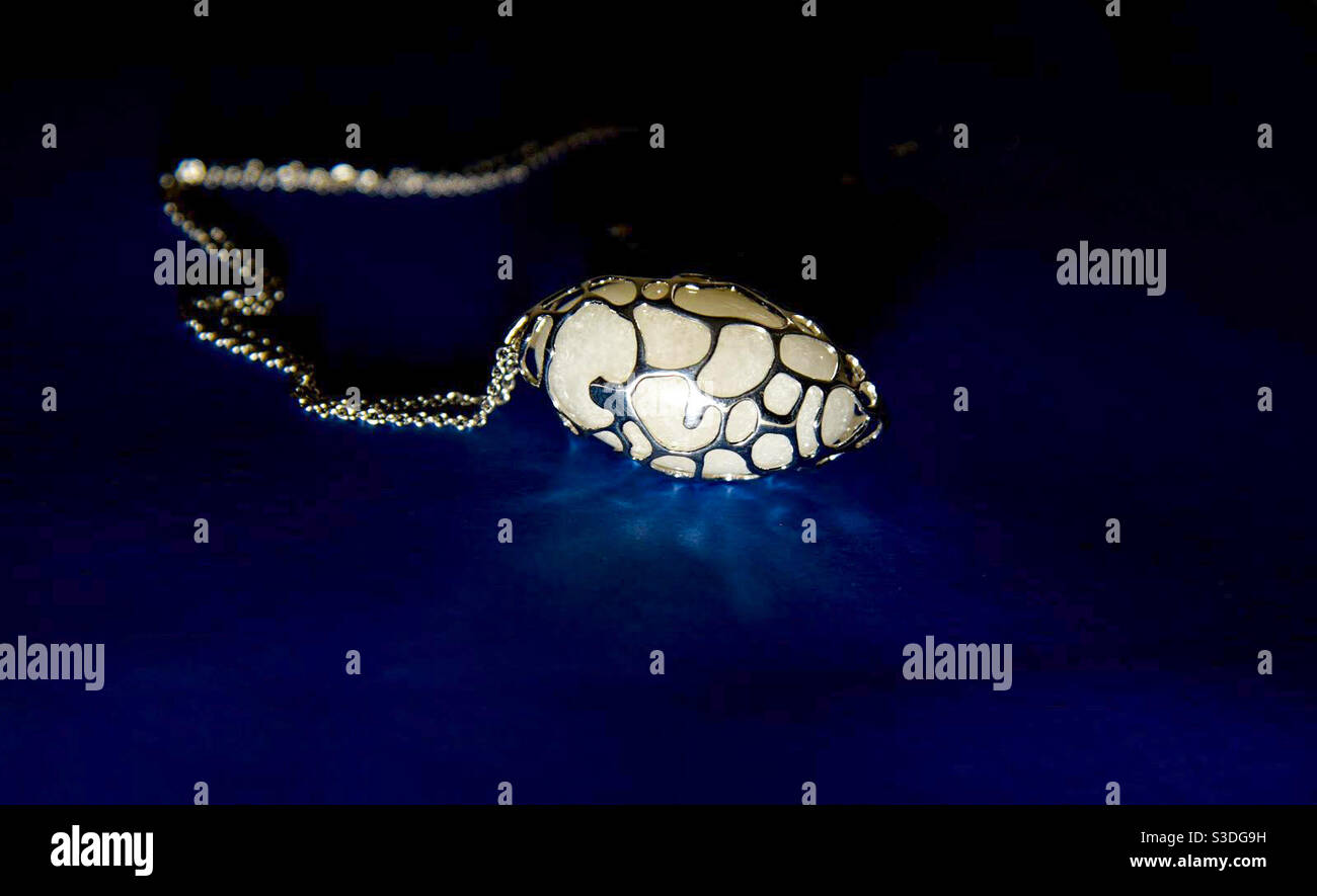 an oval-shaped jewel and it’s reflection on a blue background Stock ...