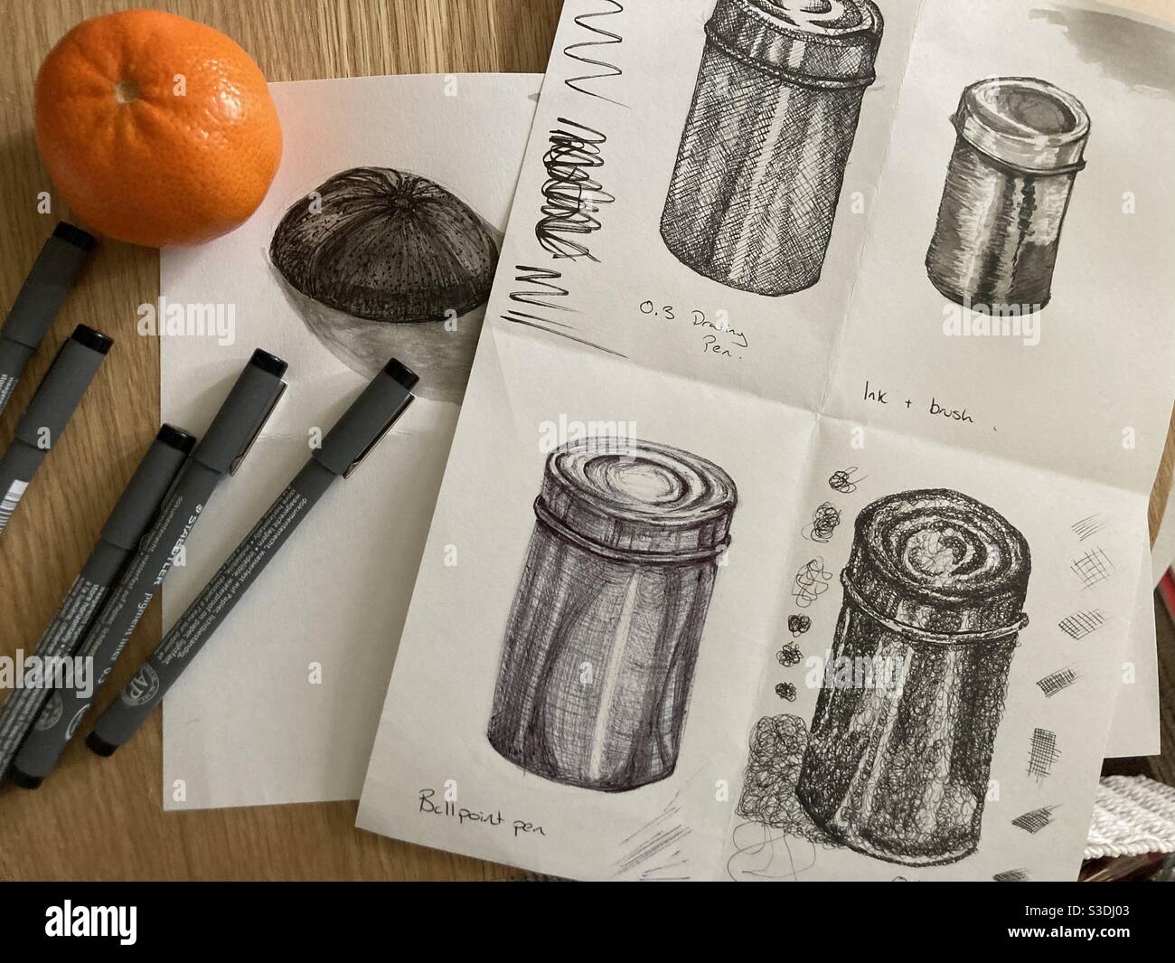 A flat lay of some sketches and drawing pens representing somebody who ...