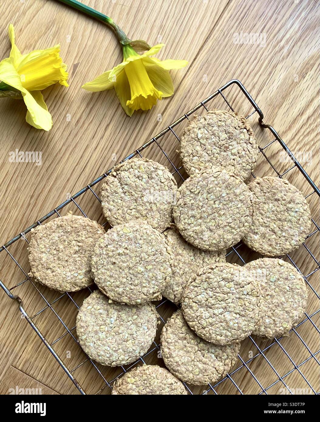 Freshly baked biscuits on cooling rack with daffodils Stock Photo - Alamy
