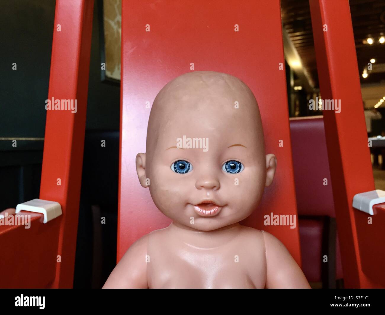 Doll on red chair Stock Photo - Alamy