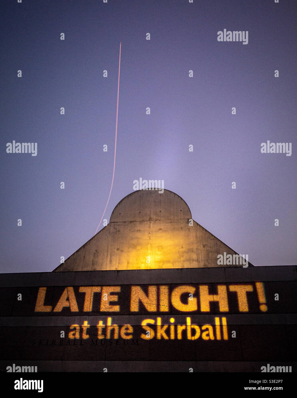Words projected on Skirball and contrail against blue evening sky Stock ...