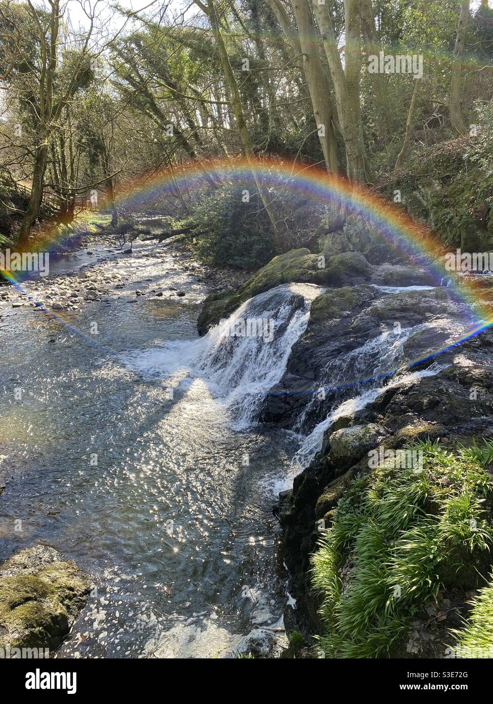 Rainbow over waterfall Stock Photo - Alamy