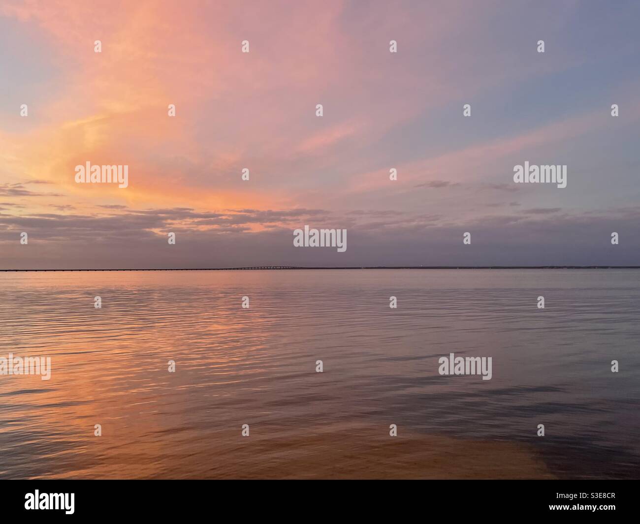 Bright colorful sunset over bay water with color reflections onto the ...