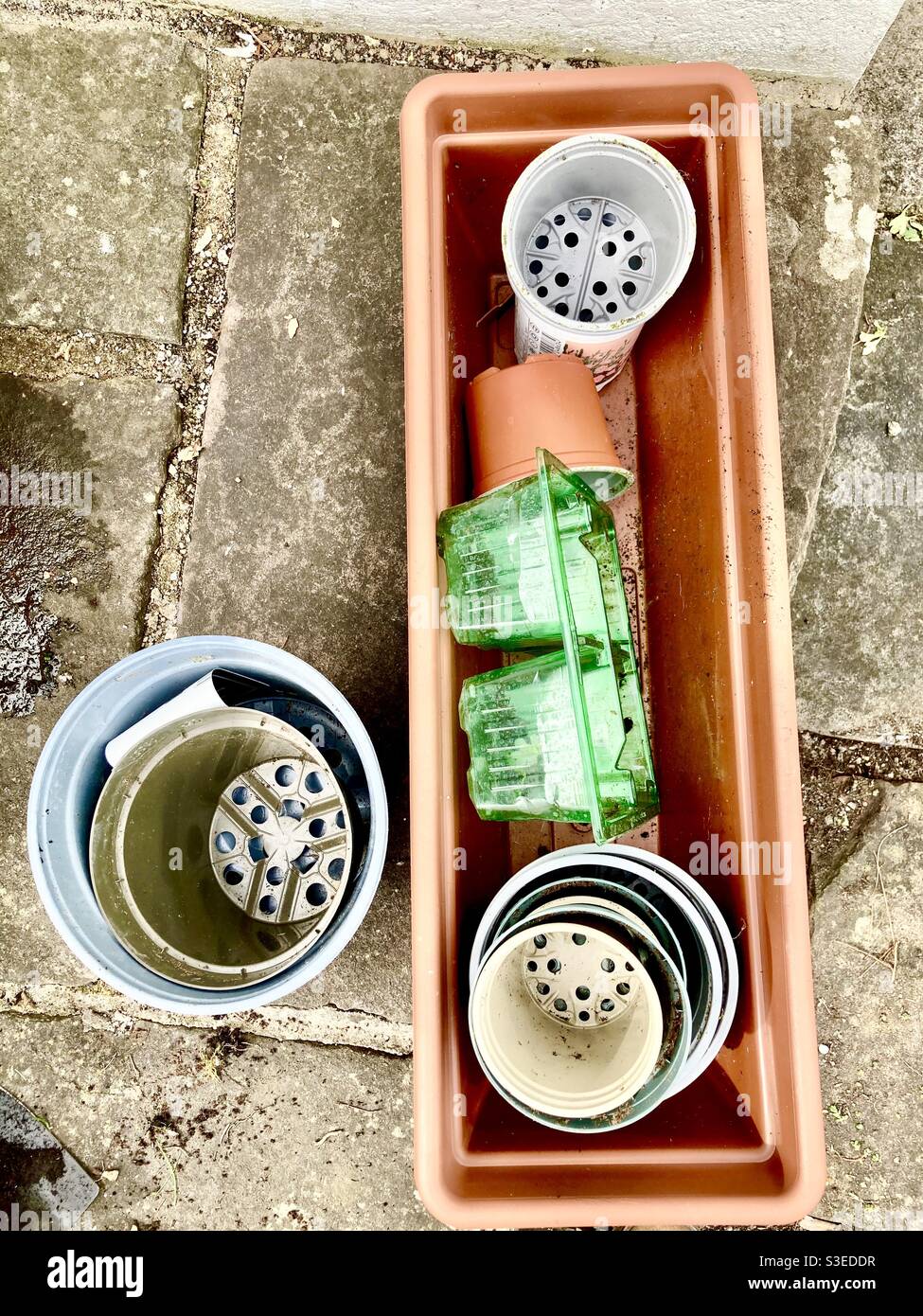 A collection of empty plastic plant pots for seeds in a garden on a ...