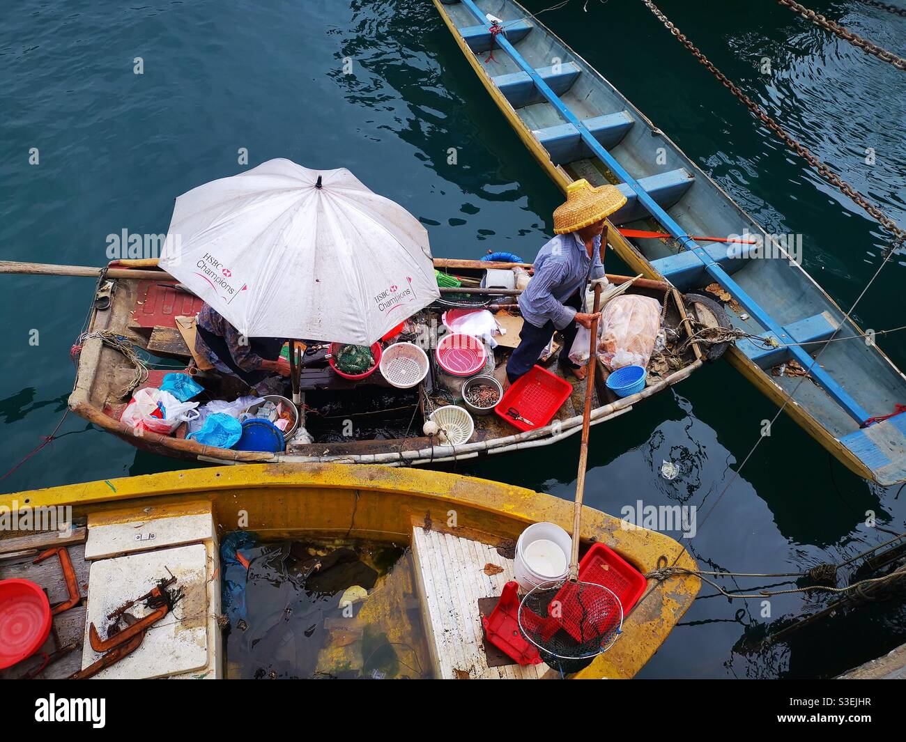 A Chinese fisherman selling fish and seafood from his boat in the ...