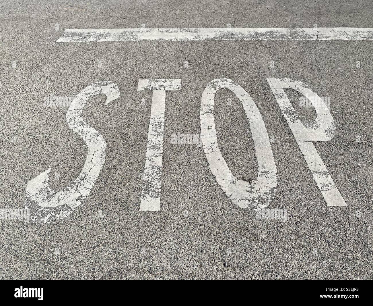 The word stop painted in white on an asphalt road at a junction Stock ...