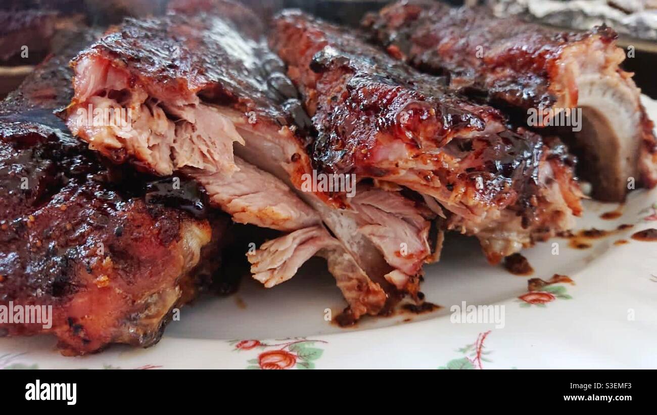 A photograph of cooked bbq pork ribs sliced up on a plate ready to eat ...
