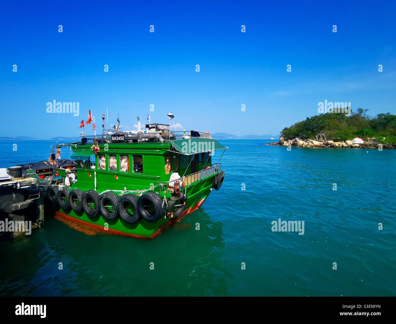 A colorful green sampan boat docking in Yung shue wan on lamma island ...