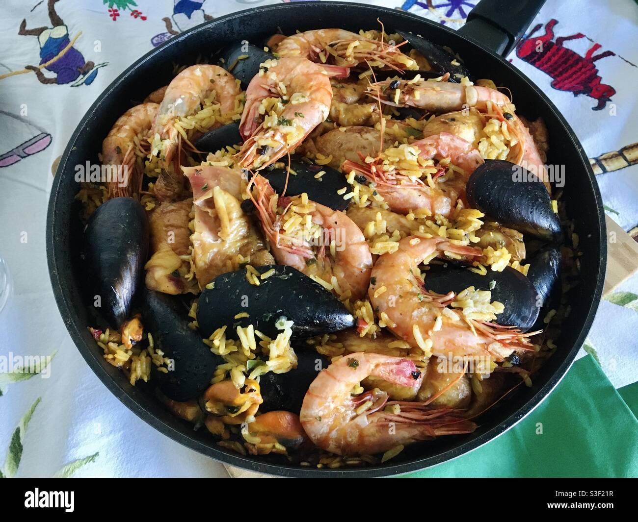 Paella with shrimps, muscles, curry rice in a pan Stock Photo - Alamy