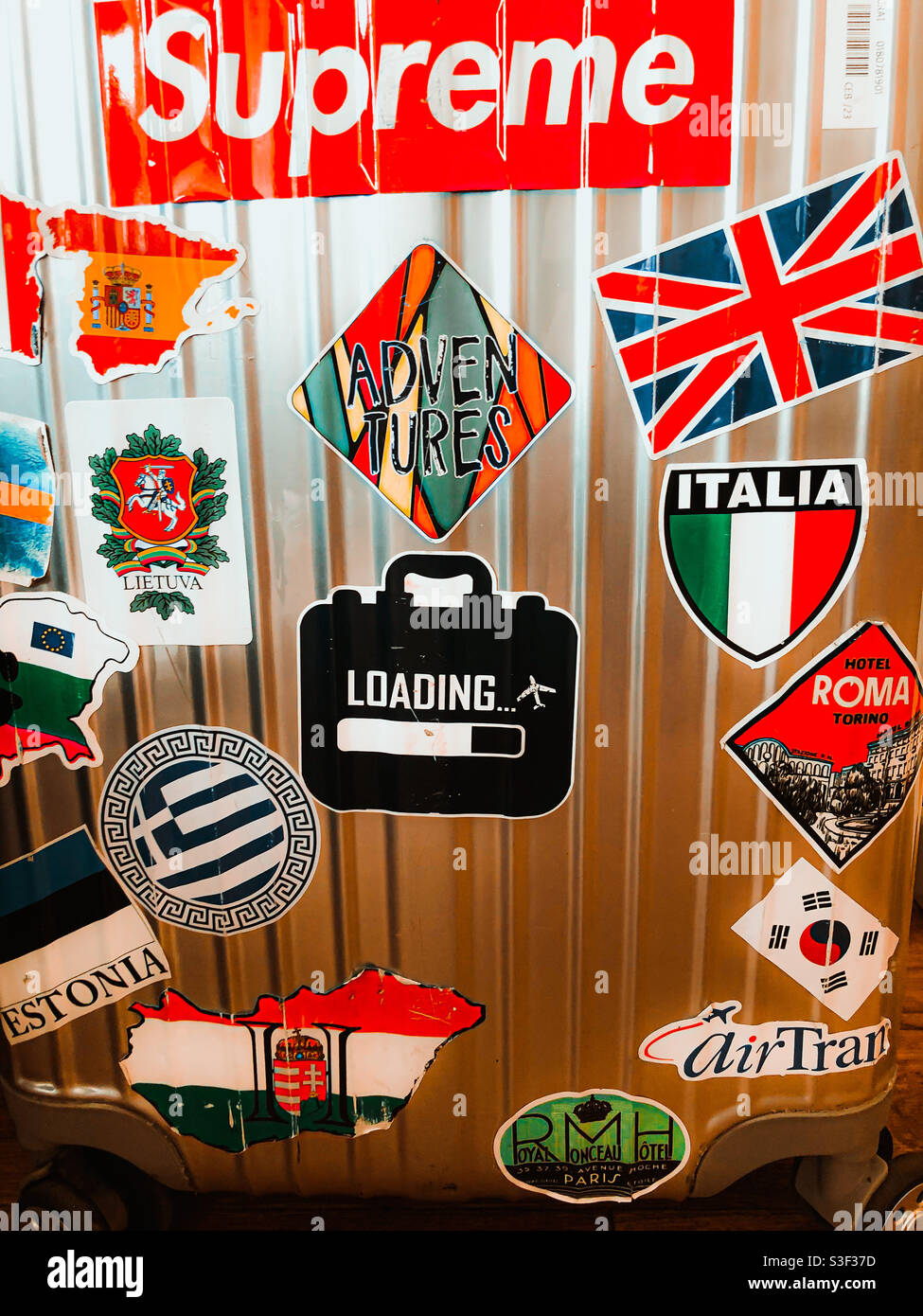 Metal suitcase covered with stickers bought from different countries ...