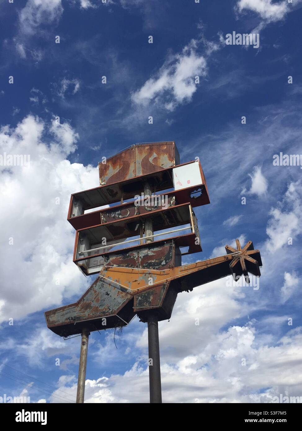 Large old rusty cowboy boot sign against a cloud filled blue sky Stock ...