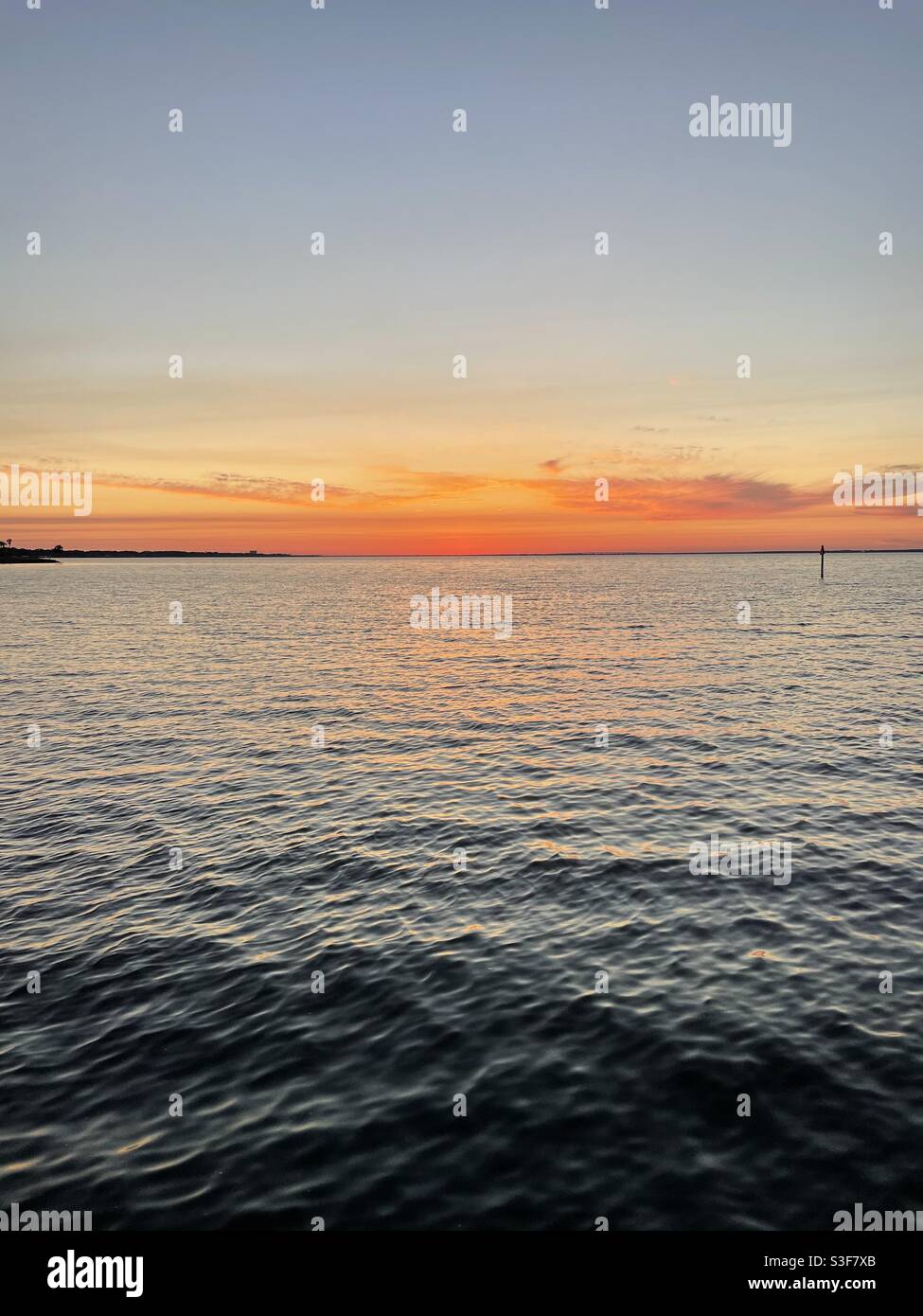 Colorful sunset skies over bay water Stock Photo - Alamy