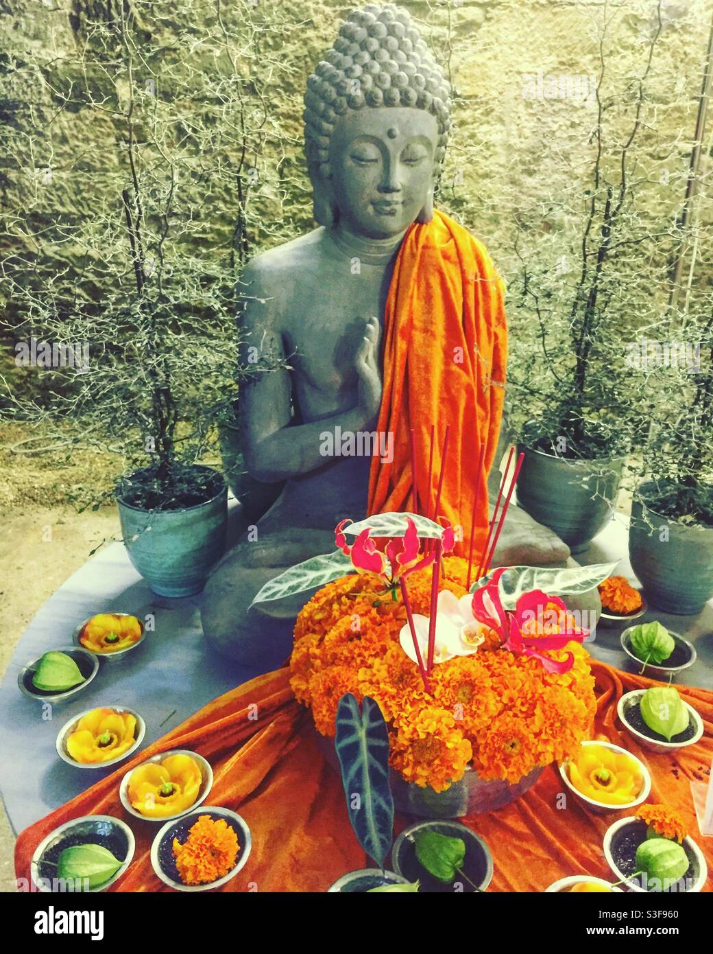 Peaceful Buddha sculpture with fruit filled sacrificial bowls Stock ...