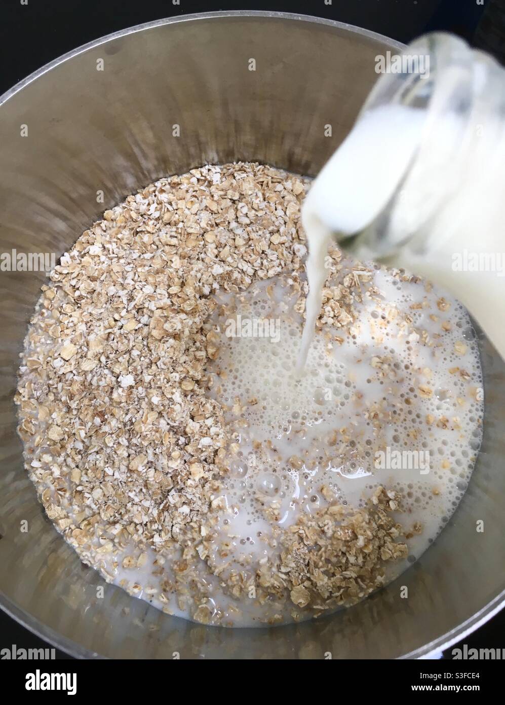 Milk pouring out of bottle into oats hi-res stock photography and ...