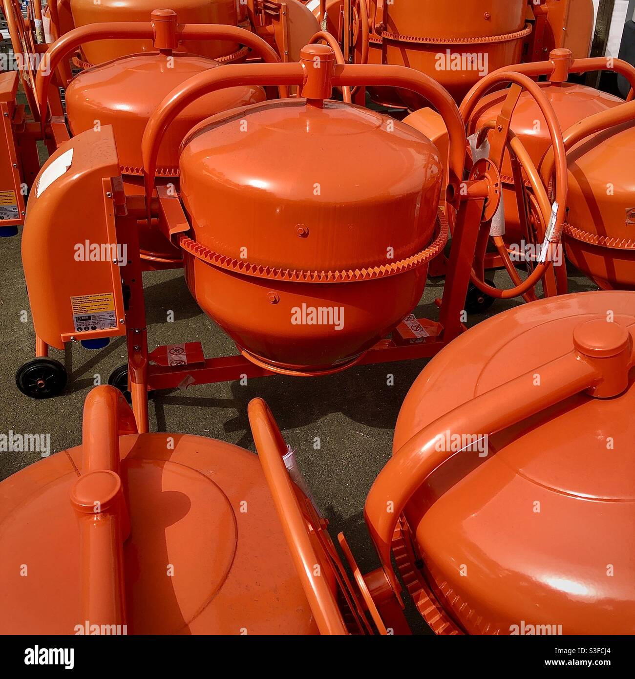 Orange cement mixers in builders store Stock Photo - Alamy