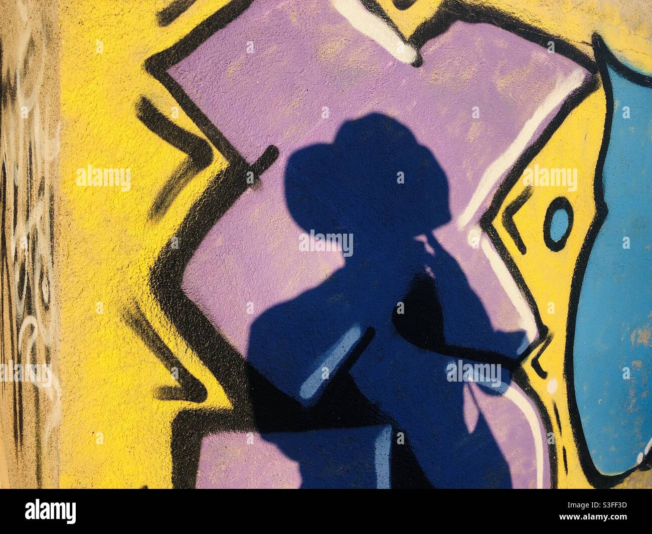 Shadow of a man on street art graffiti Stock Photo - Alamy