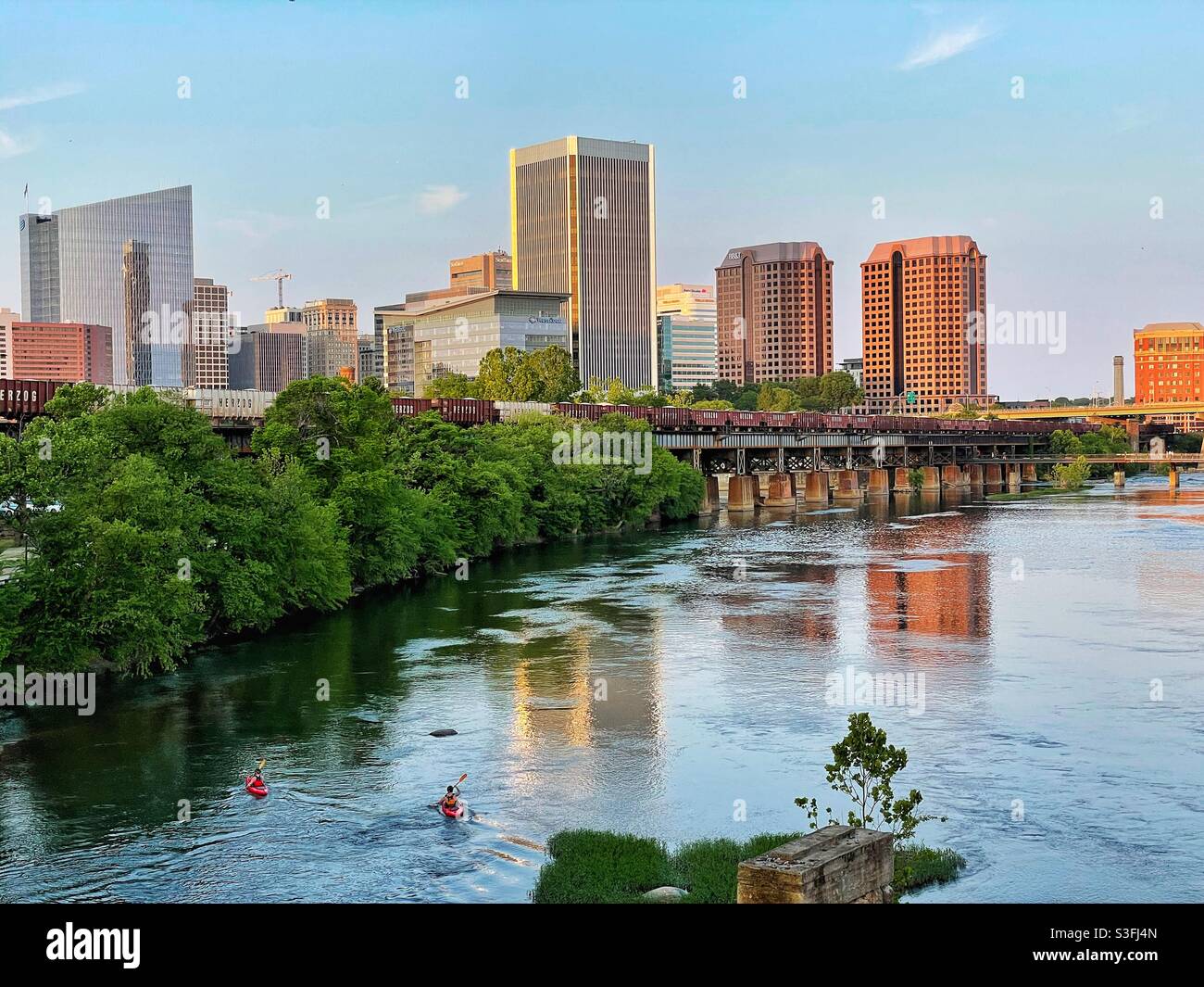 Two kayakers floating down the James River through downtown Richmond ...