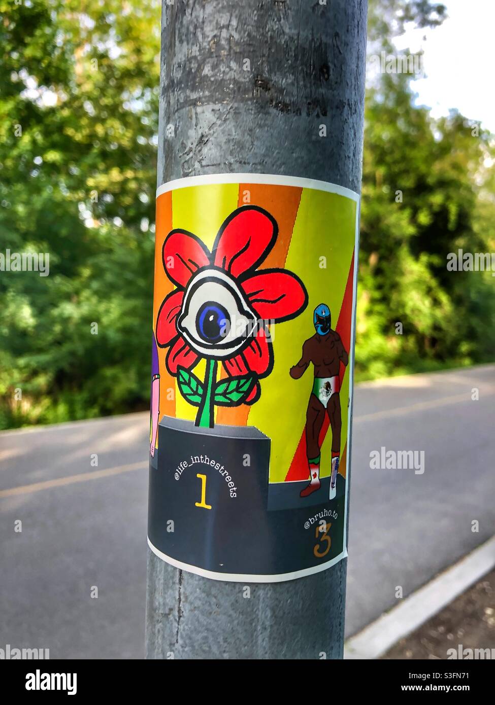 A colourful floral sticker on a street post Stock Photo - Alamy