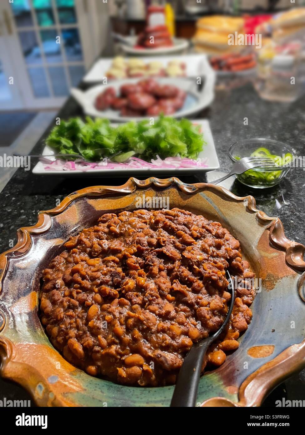 Large serving bowl of homemade baked beans on the kitchen counter with ...