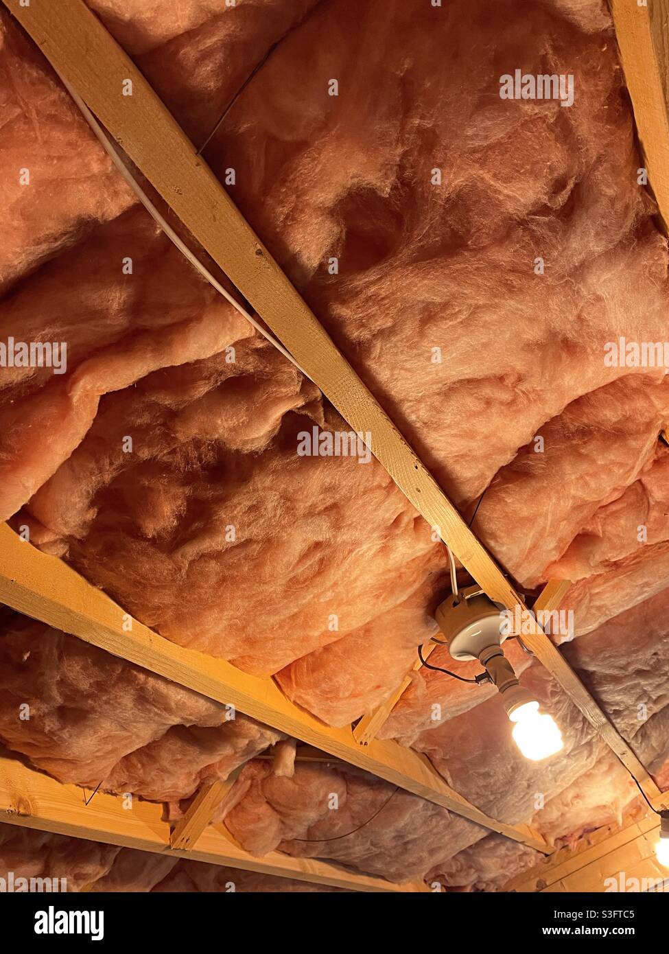 Fiberglass insulation in a residential home with an unfinished ceiling ...