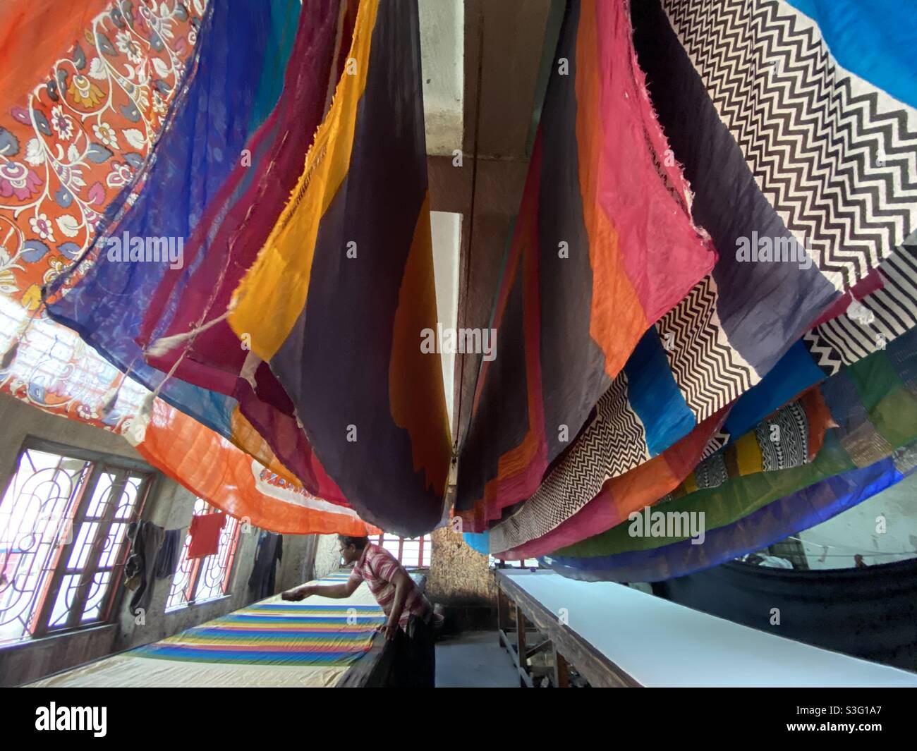 A worker painting a sari,the traditional dress of India in a sari ...