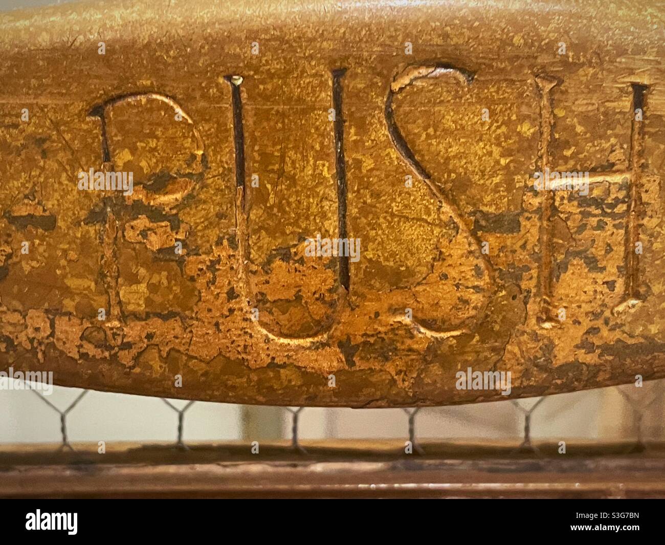 Close up of a worn weathered brass door handle with the word push ...