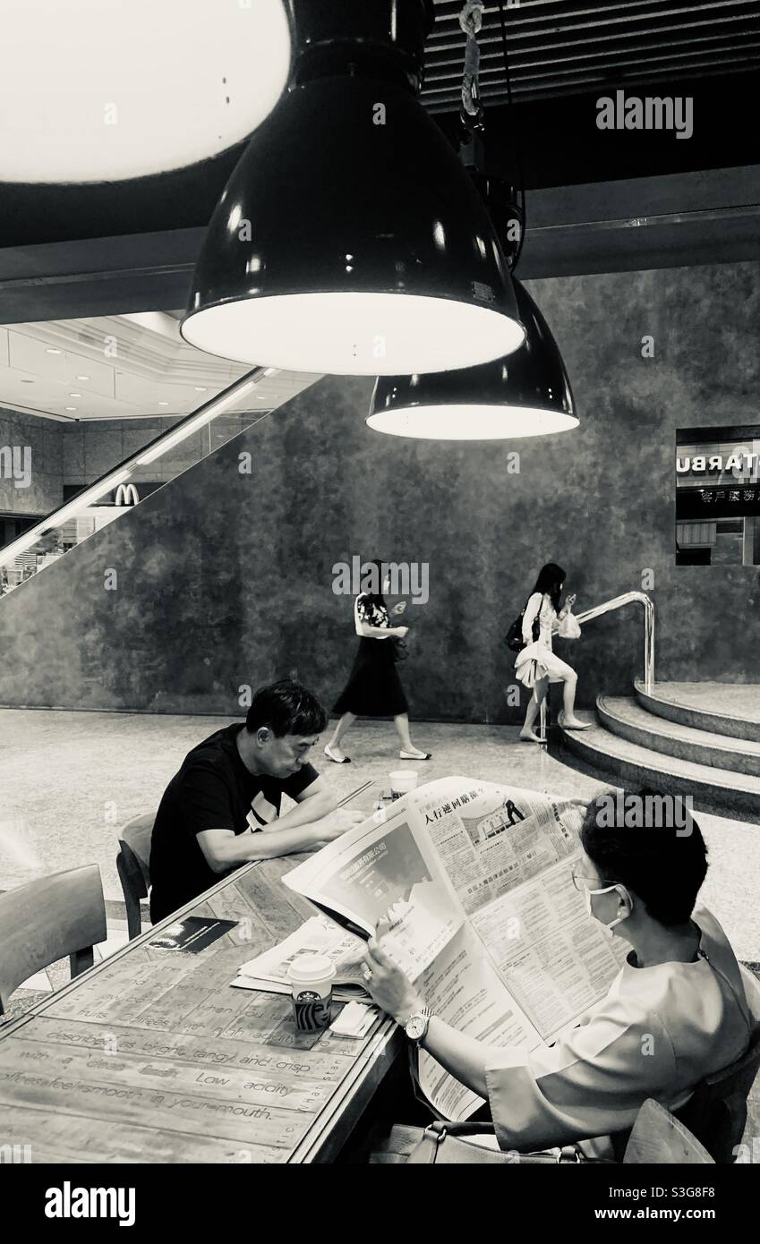 Reading the morning paper in Hong Kong Stock Photo - Alamy