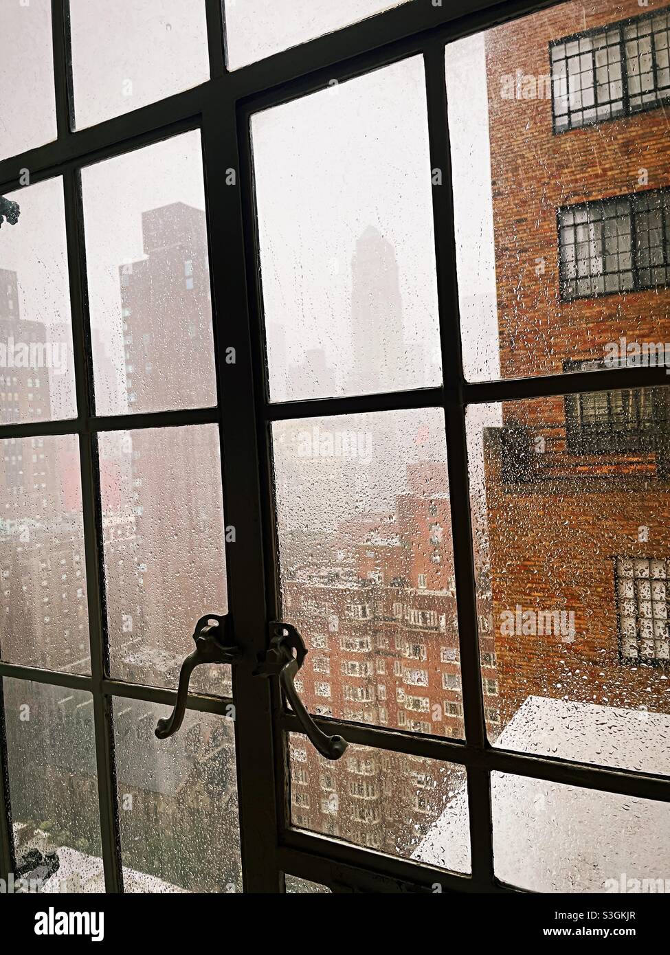 Rain storm as seen through a casement window in a high-rise New York ...