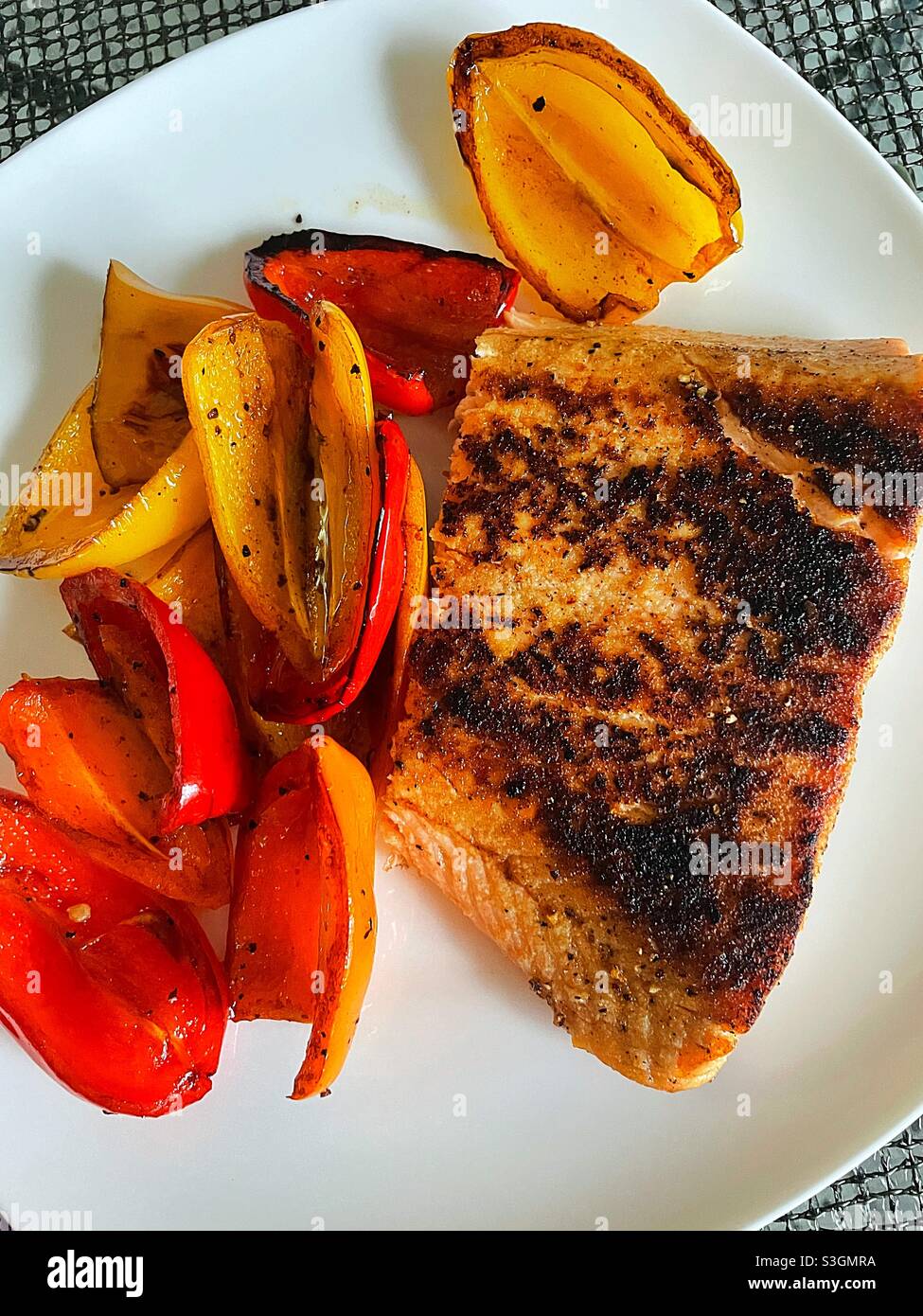 Gourmet entrée of salmon fillet accompanied by sautéed mini sweet ...