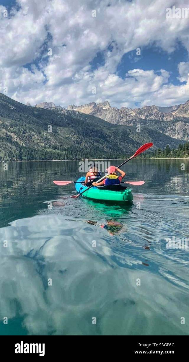 Turquoise kayak with two girls kayaking on a lake with Mountain View’s ...