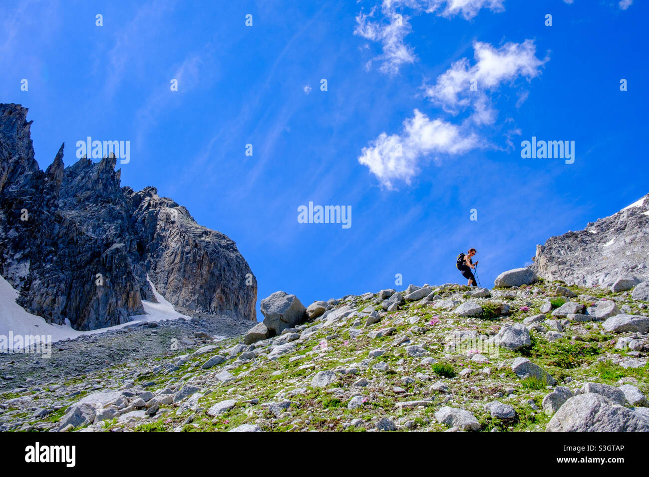 Alpinist walking on a mountain ridge Stock Photo - Alamy