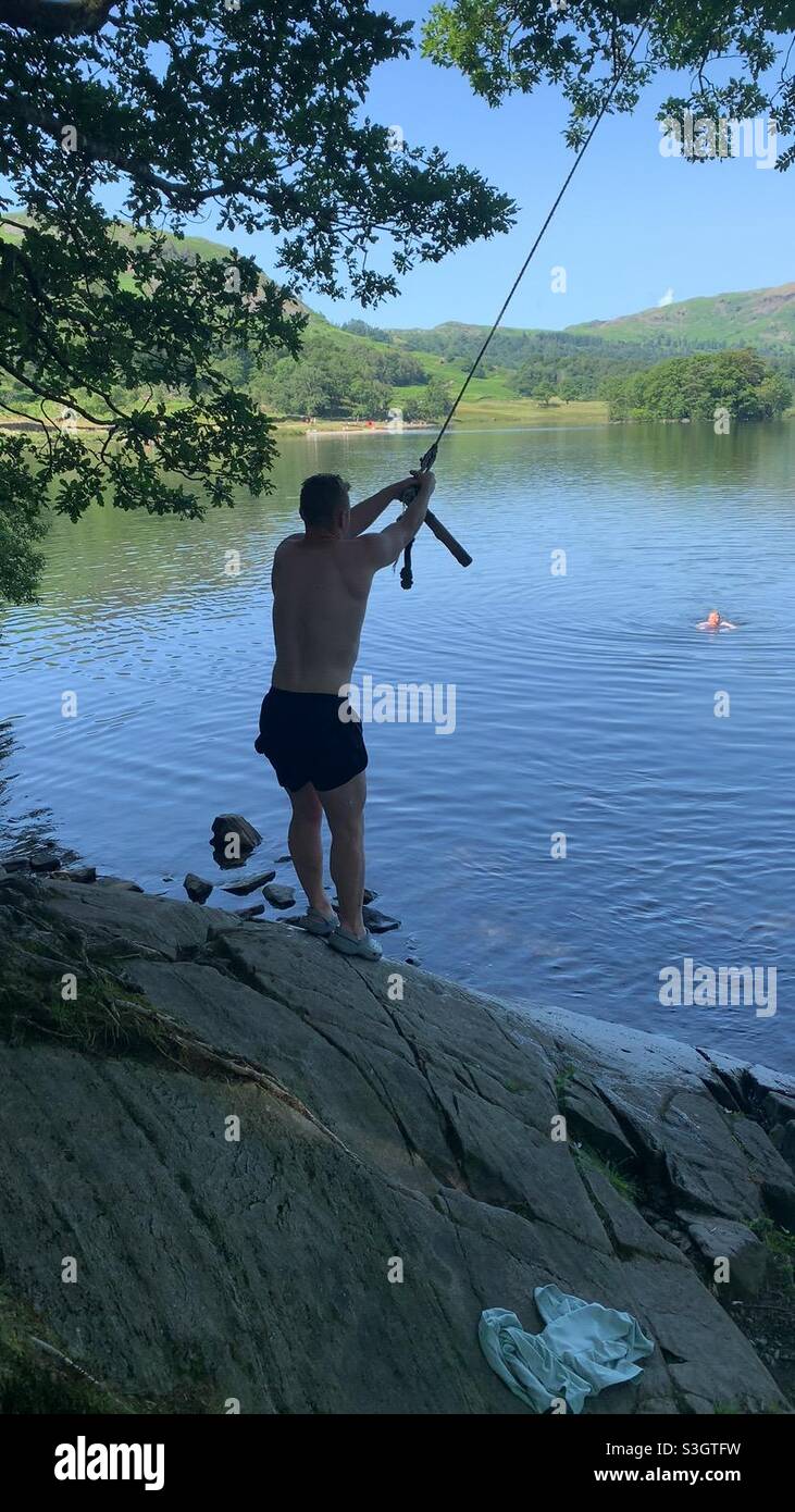 Man swinging on rope at rydal water silhouette Stock Photo - Alamy
