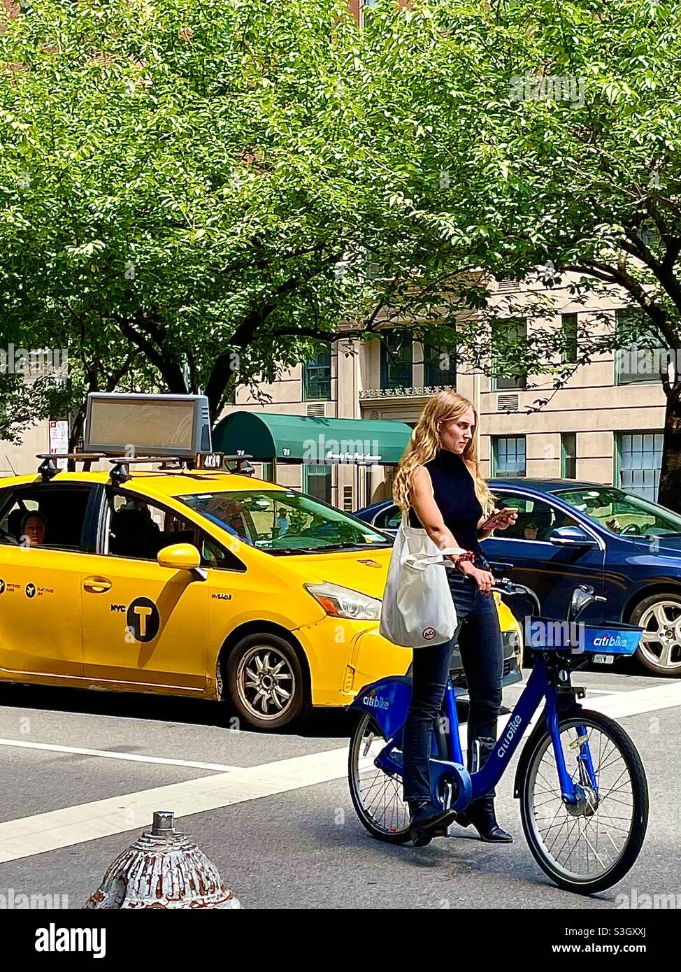 Woman on bicycle at an intersection in Manhattan, NYC, USA Stock Photo ...