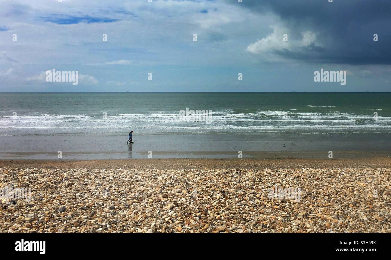 Walkers on the shingle beach at Bracklesham Bay, West Sussex Stock ...