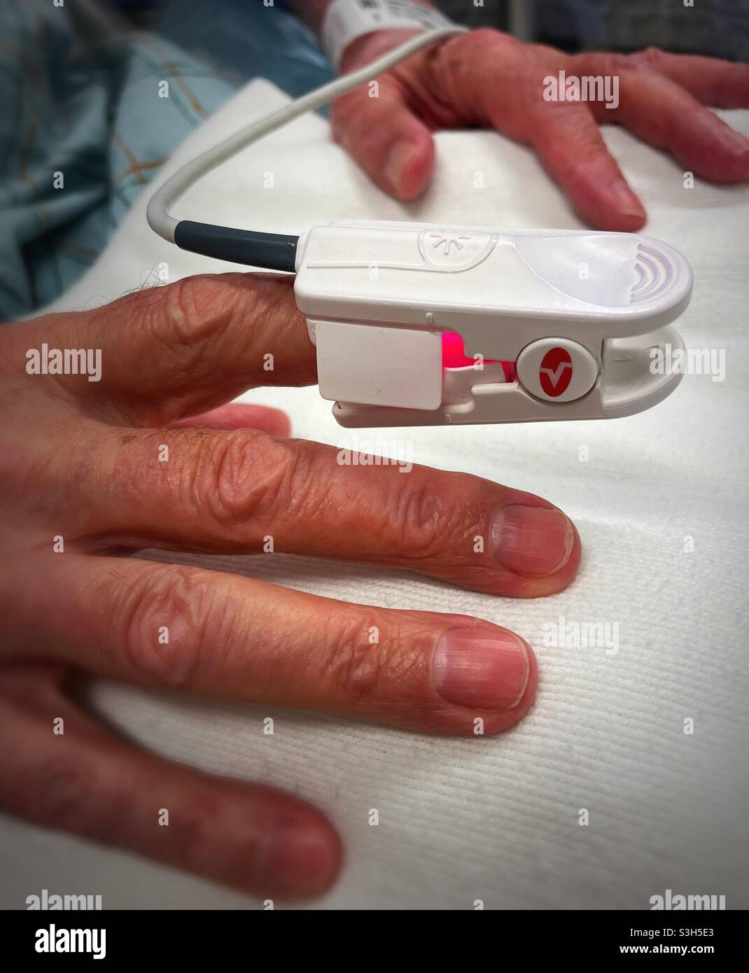 Male patient in hospital with a pulse oximeter on his finger tip in ...