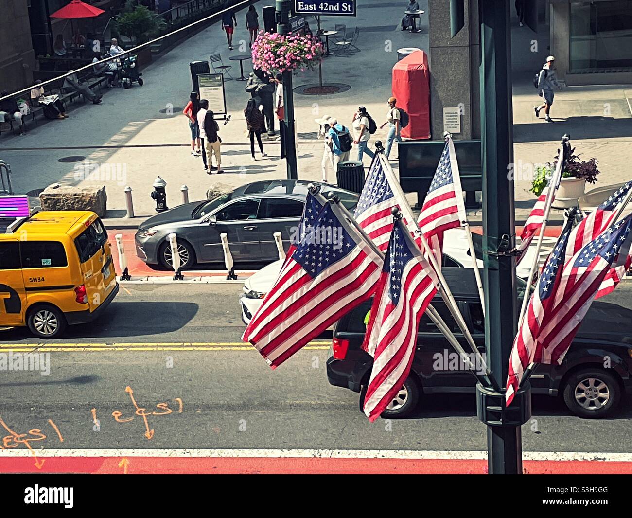 A cluster of small American flags fly above E. 42nd St. as seen from ...