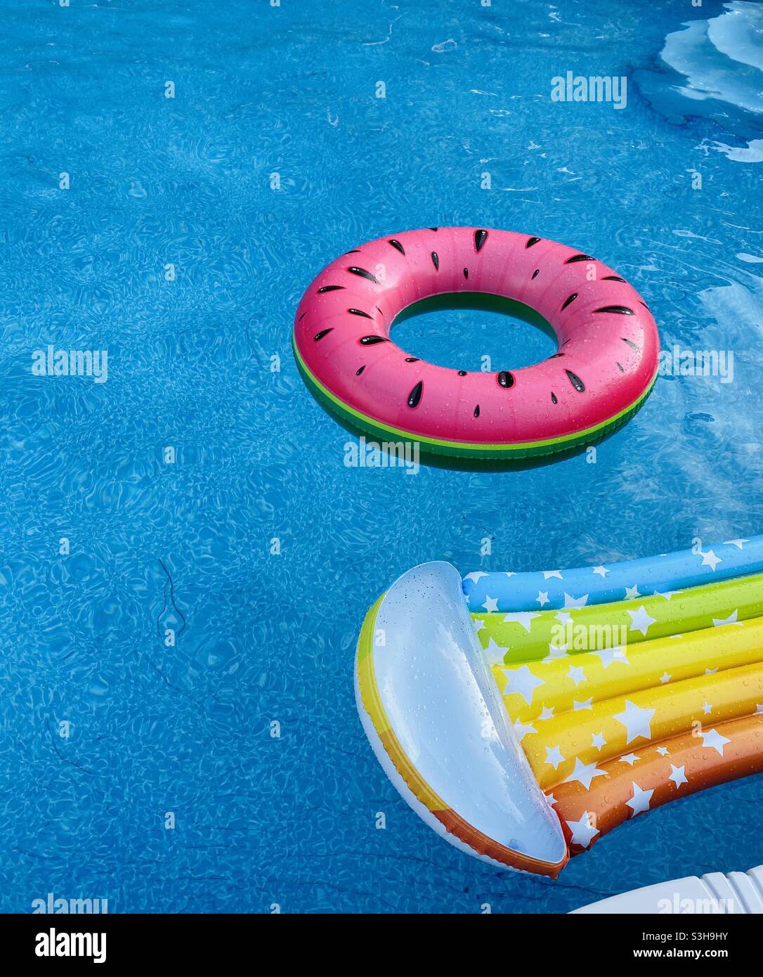 Colorful pool floaties on the water Stock Photo - Alamy