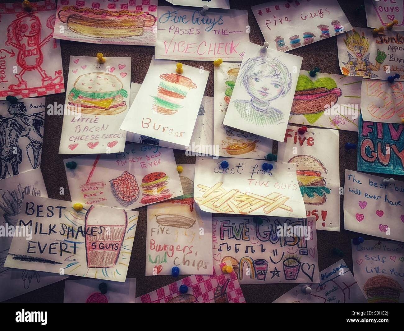 Pin board in Five Guys restaurant with drawings pinned to it praising ...