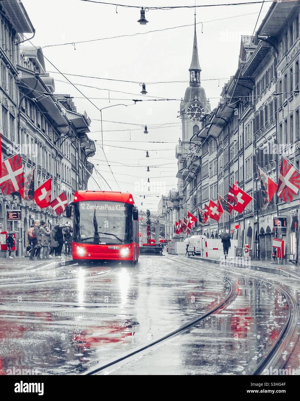 Red trolleybus in centre of Bern on a rainy day Stock Photo - Alamy