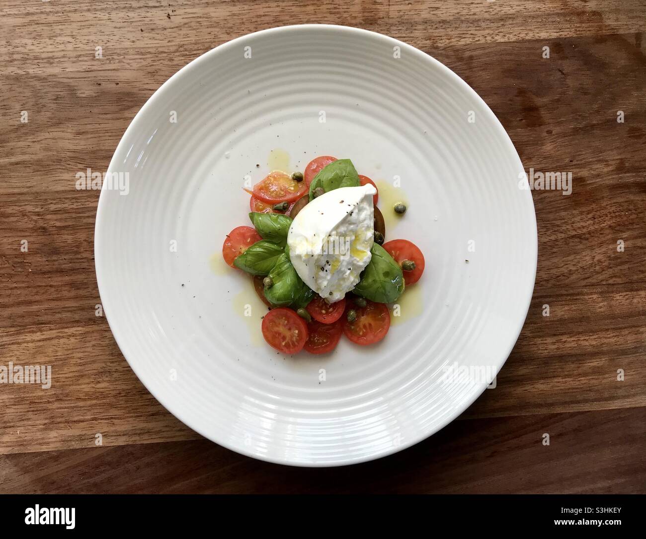 Homegrown tomato dish with basil mozzarella, capers and olive oil Stock ...