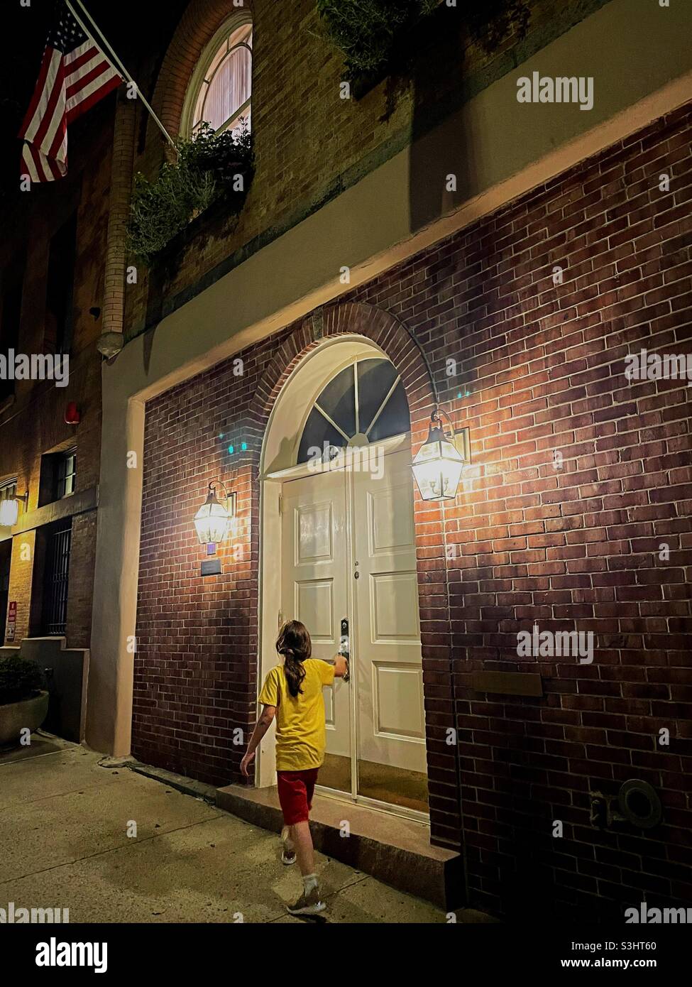 A small girl walks in front of a well lit townhouse door in the Murray ...