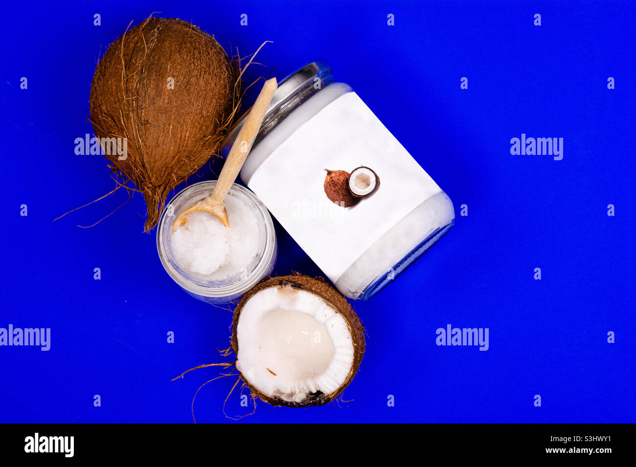 Coconut oil and fresh coconuts on a blue background Stock Photo - Alamy