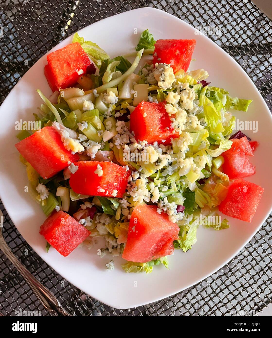 Fresh summertime salad with watermelon cubes and crumbled blue cheese ...