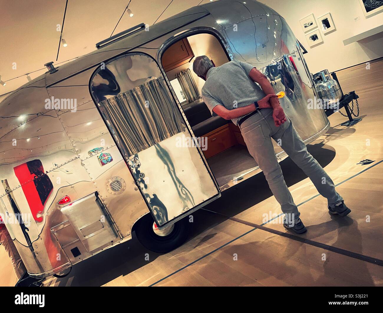 A museum goer views a vintage airstream travel trailer as part of the ...